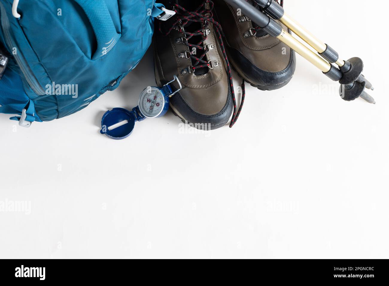 Close up of backpack, trekking shoes, sticks and compass on white ...