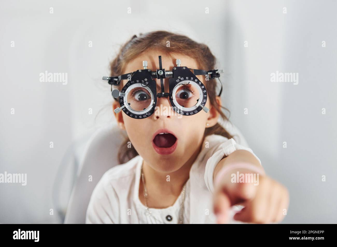 Cute little girl is in ophthalmology clinic with special tool on eyes ...