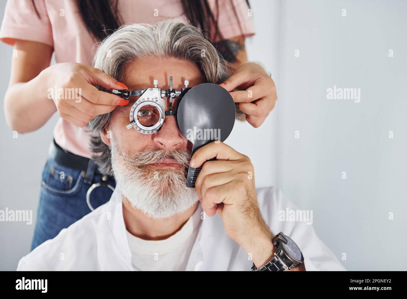 Getting tested by woman worker. Senior man with grey hair and beard is ...