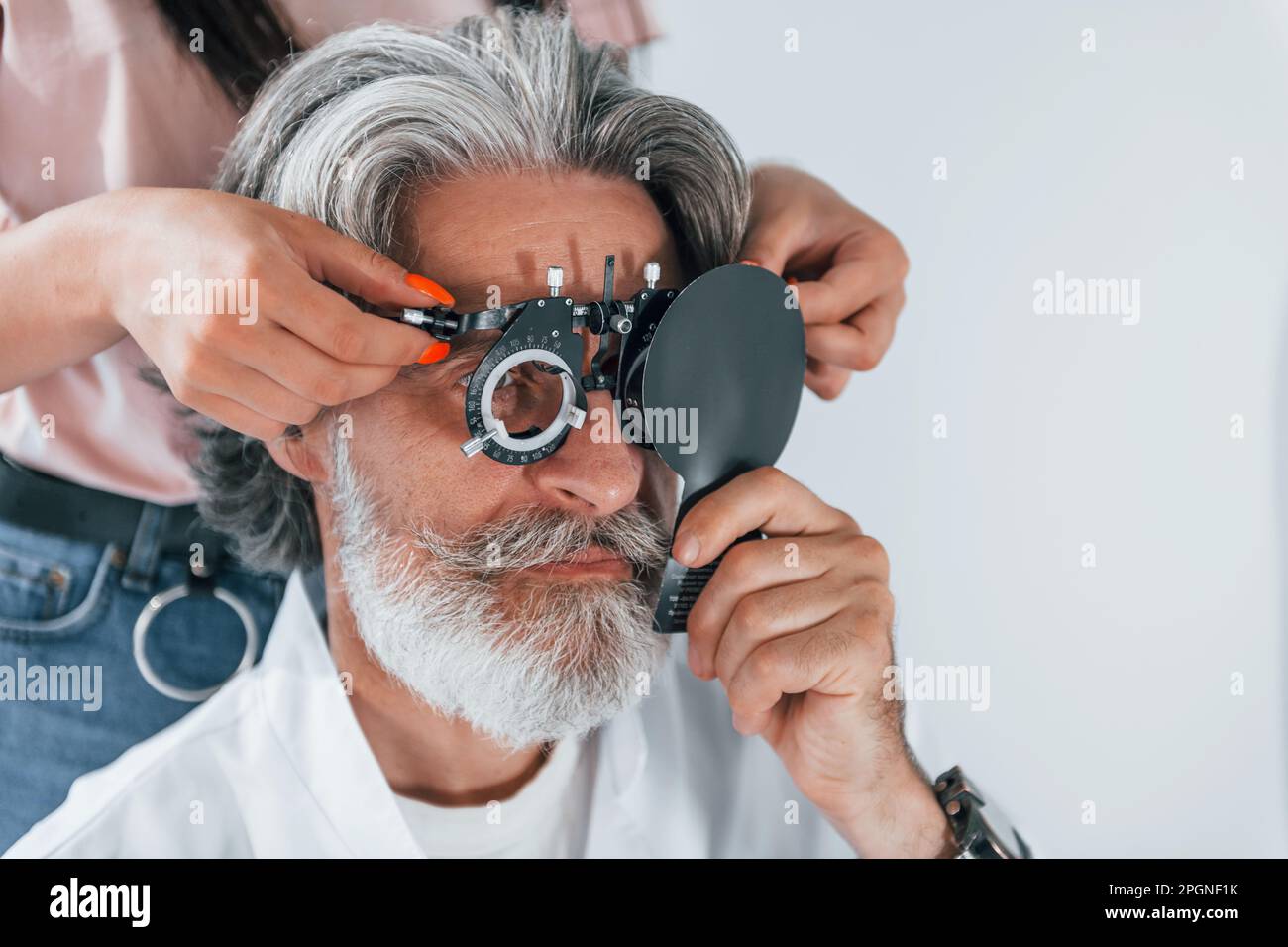 Getting tested by woman worker. Senior man with grey hair and beard is ...