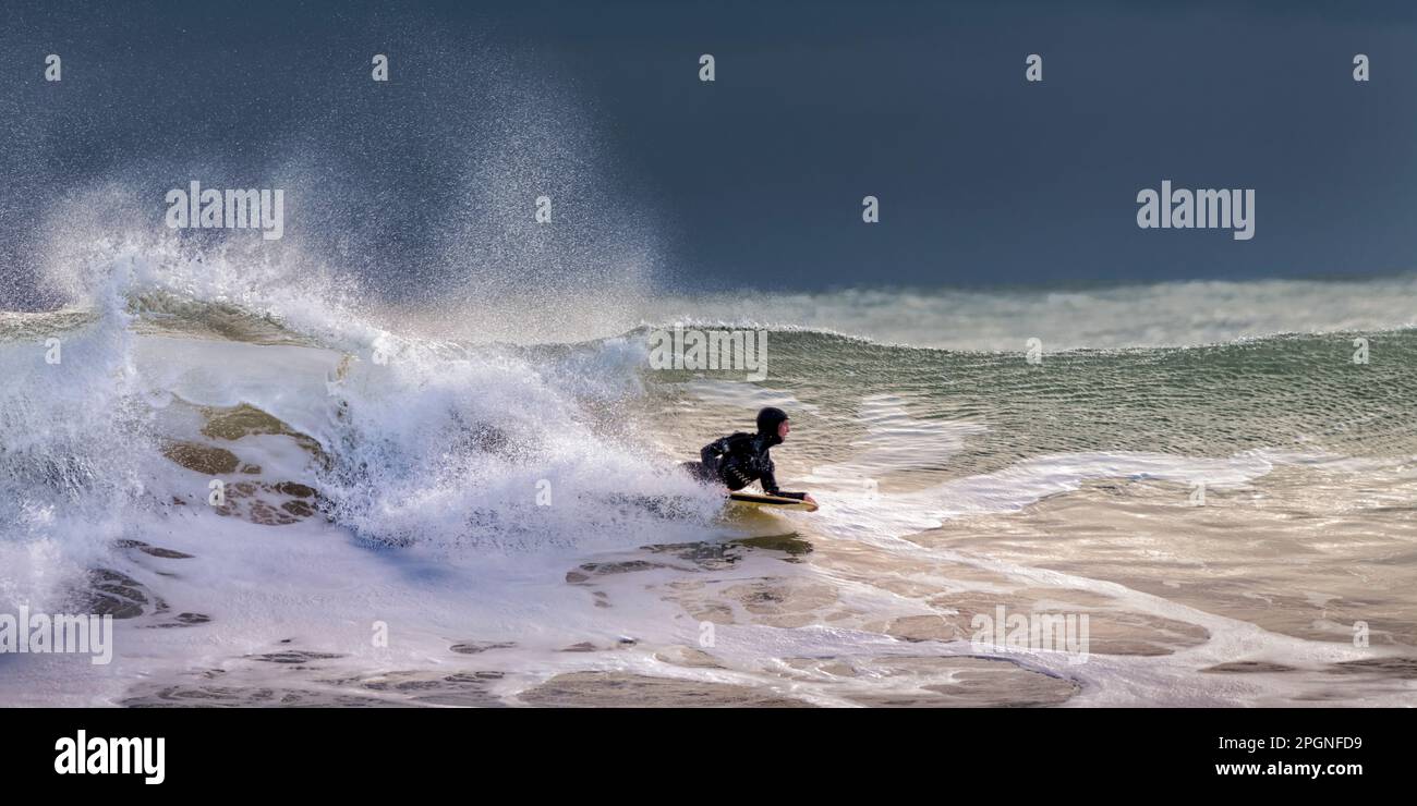 Man swimming with surfboard in wavy sea on vacation Stock Photo - Alamy