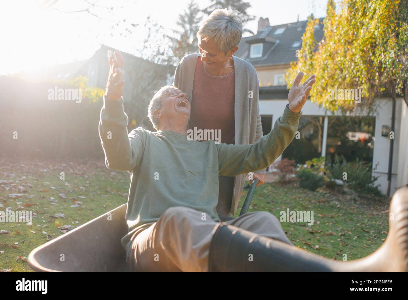 Happy senior couple having fun with wheelbarrow in garden Stock Photo ...