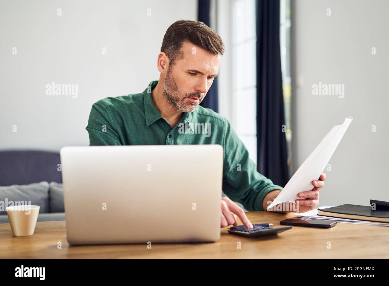 Worried man doing paperwork calculating finaces Stock Photo - Alamy