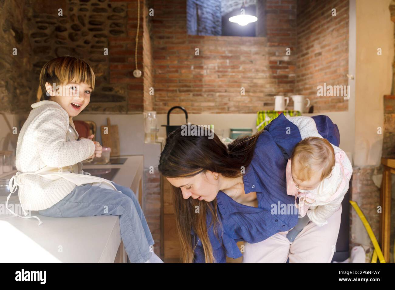 Cute smiling boy sitting on kitchen counter at home Stock Photo - Alamy