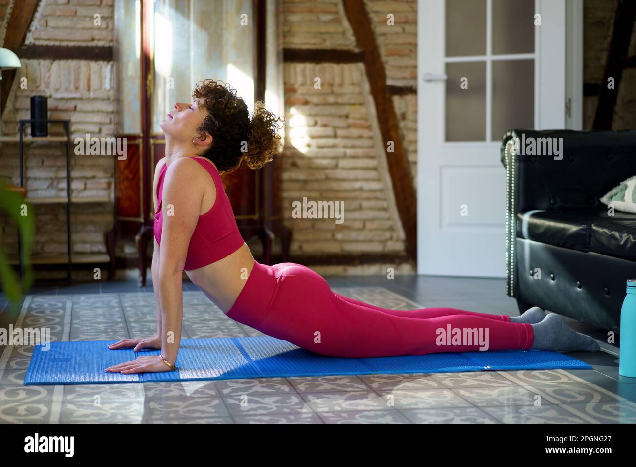 Woman practicing upward facing dog position at home Stock Photo - Alamy