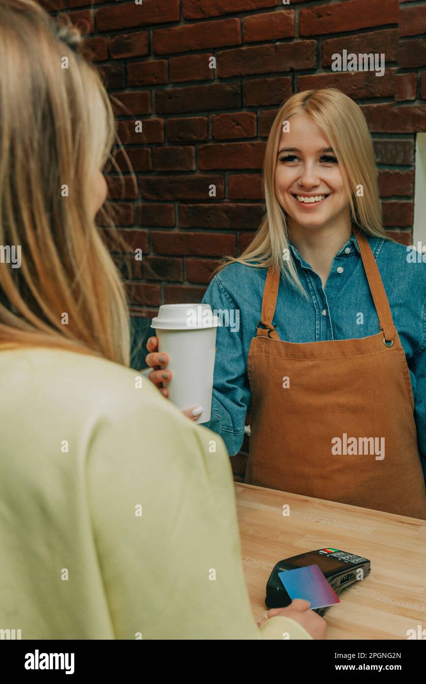 Smiling owner giving coffee to customer at coffee shop Stock Photo - Alamy
