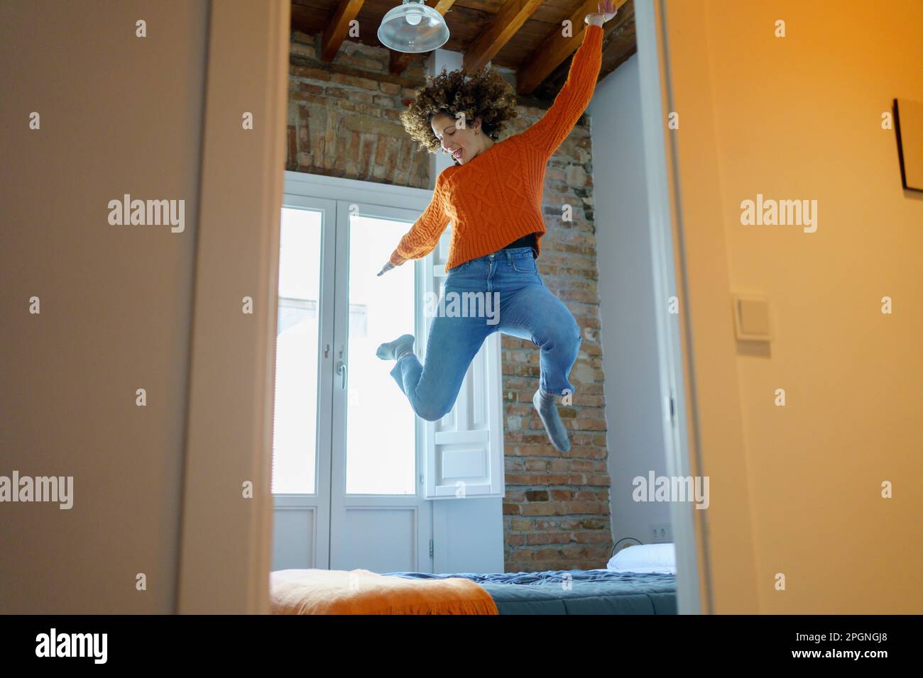 Woman jumping on bed hi-res stock photography and images - Alamy