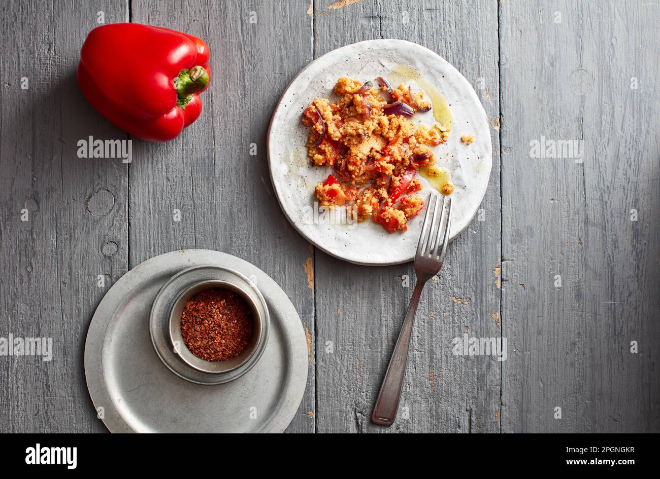 Raw bell pepper, chili powder and plate of ready-to-eat couscous Stock ...
