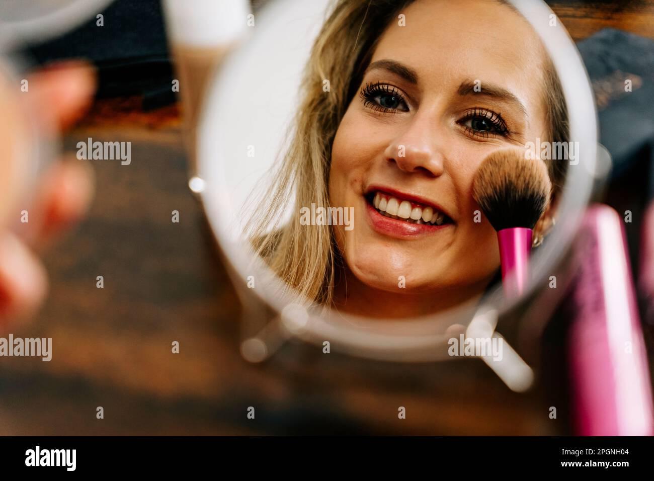 Reflection of woman applying makeup in mirror Stock Photo - Alamy