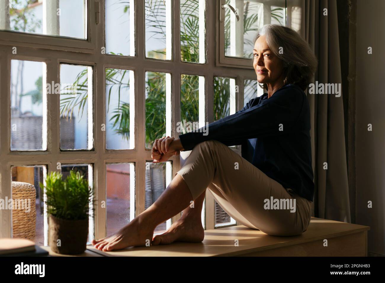 Pensive woman sitting on window sill hi-res stock photography and ...
