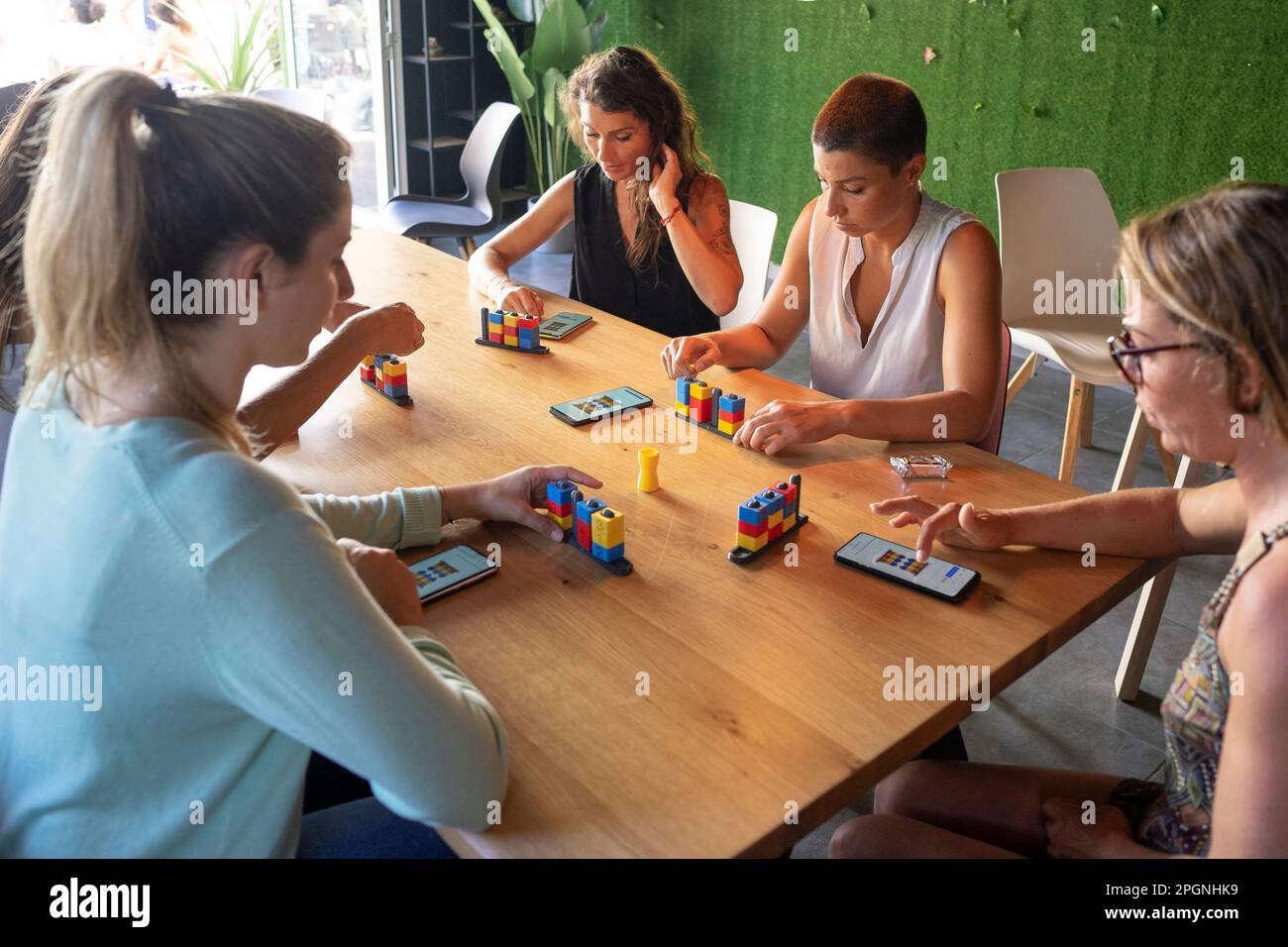 Businesswomen with smart phone building blocks at workplace Stock Photo ...