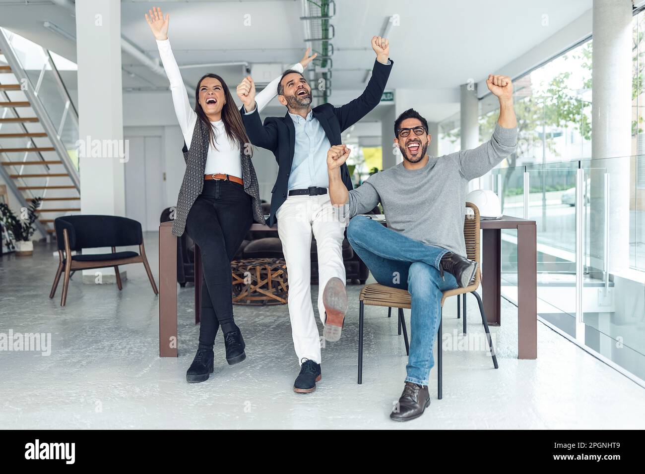 Successful businessmen and businesswoman cheering in office Stock Photo ...