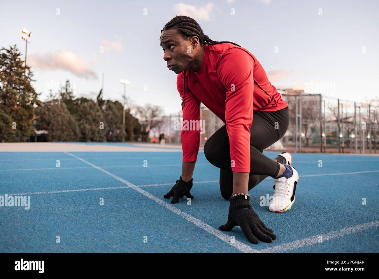 Determined athlete in starting position preparing to run on track Stock ...