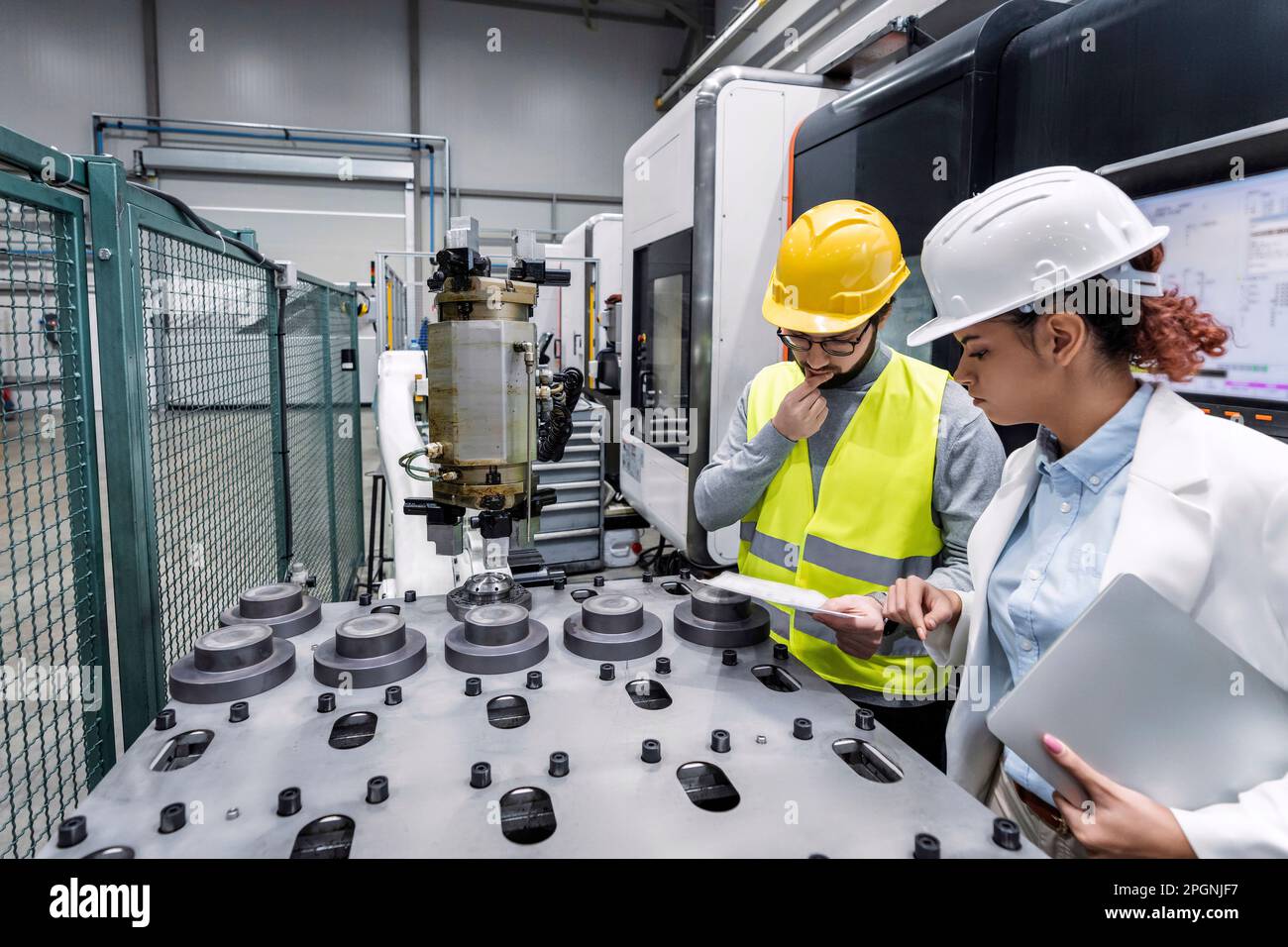 Engineer and colleague checking quality in factory Stock Photo - Alamy