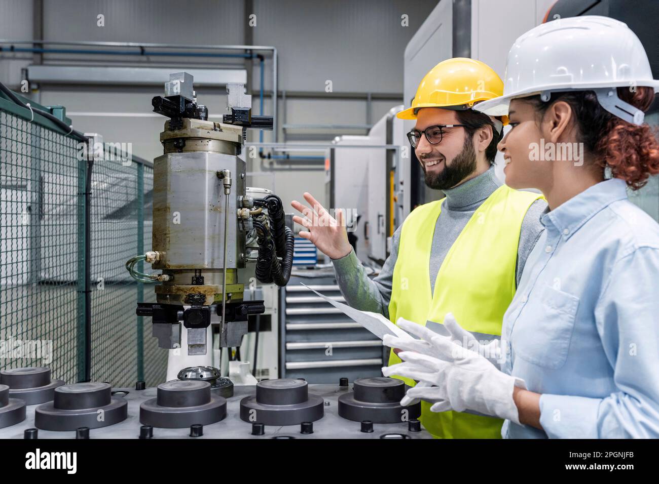 Happy engineer holding blueprint with colleague in office Stock Photo ...