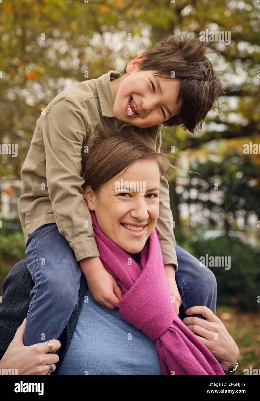 Smiling woman carrying boy on shoulders at park Stock Photo - Alamy