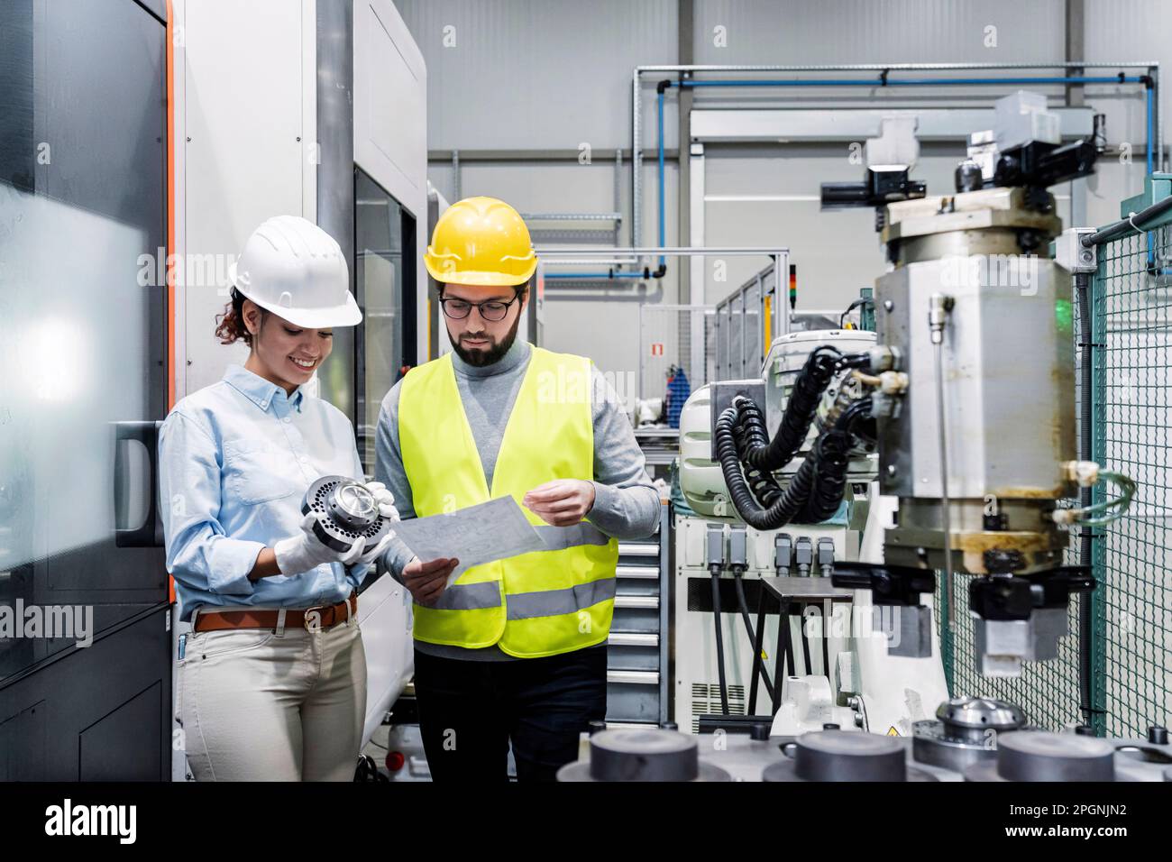 Smiling engineer consulting with colleague in factory Stock Photo - Alamy