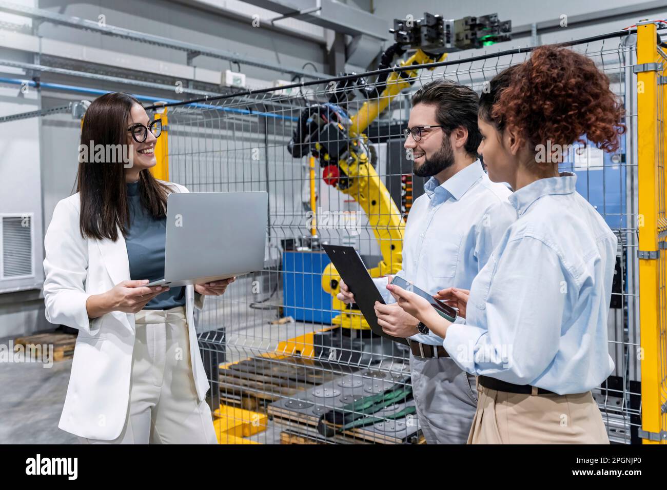 Happy business people having discussion in factory Stock Photo - Alamy