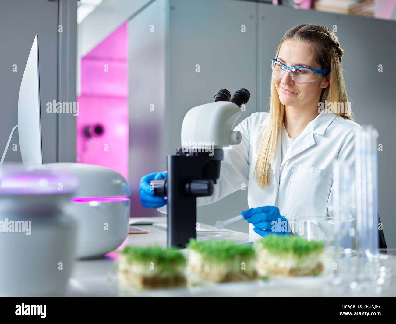 Smiling young scientist working with microscope in laboratory Stock ...