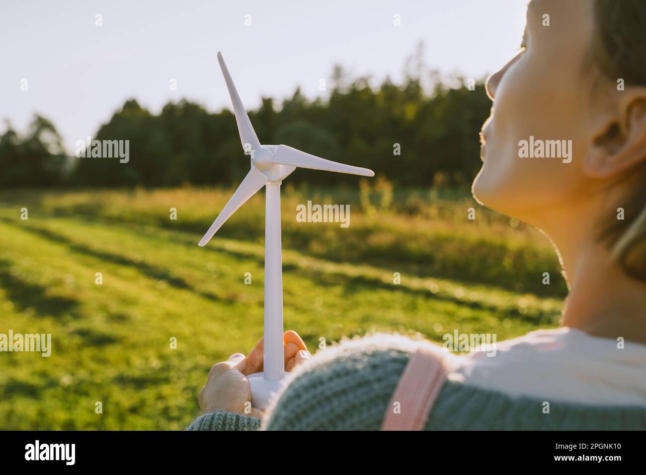 Woman blowing wind turbine model Stock Photo - Alamy
