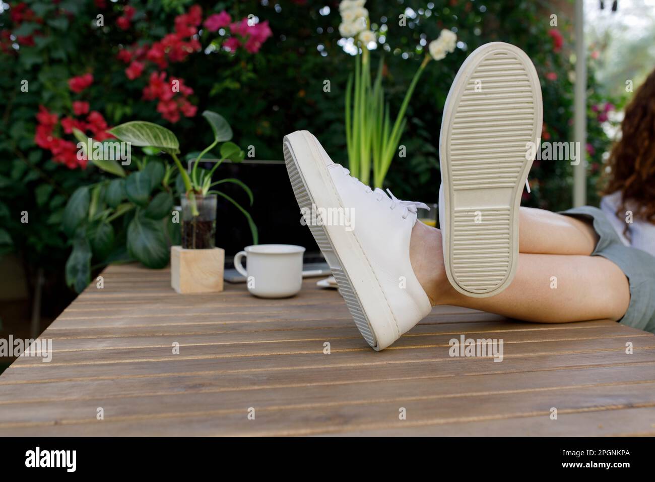 Woman with feet up on table at backyard Stock Photo - Alamy