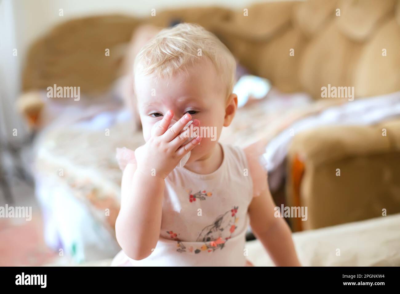 The baby pulls out her nose with her nose during a runny nose. A sick ...