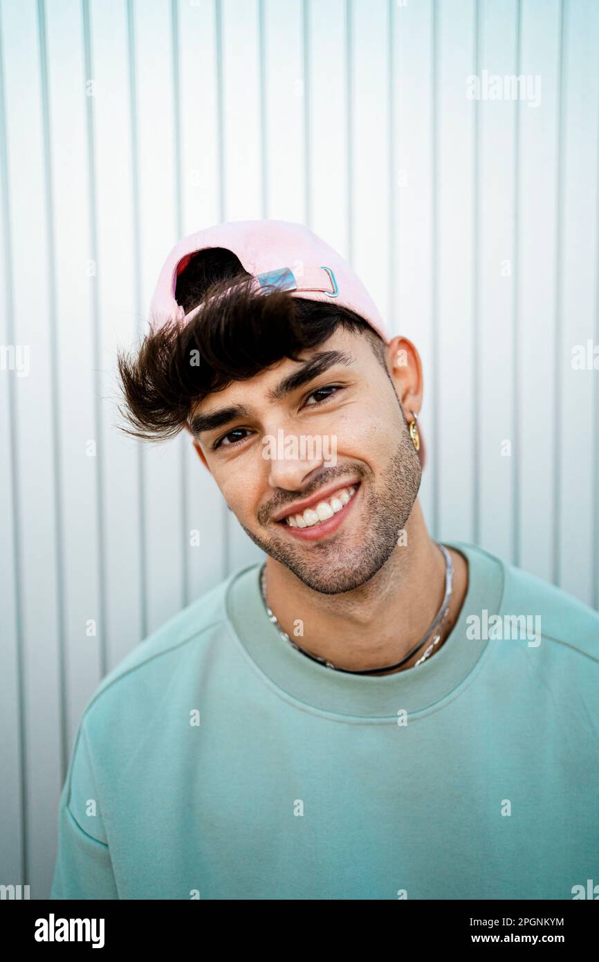 Cheerful man wearing cap in front of white wall Stock Photo - Alamy