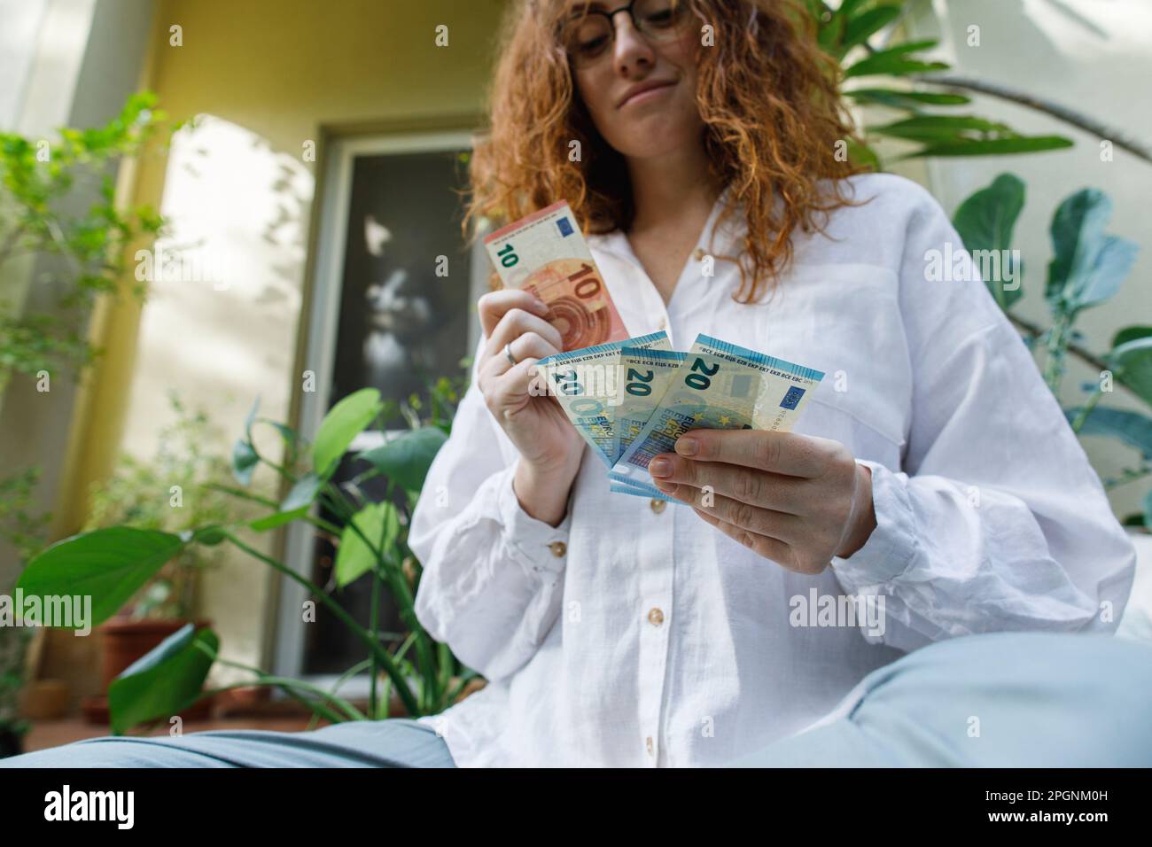 Woman counting paper currency in backyard Stock Photo - Alamy