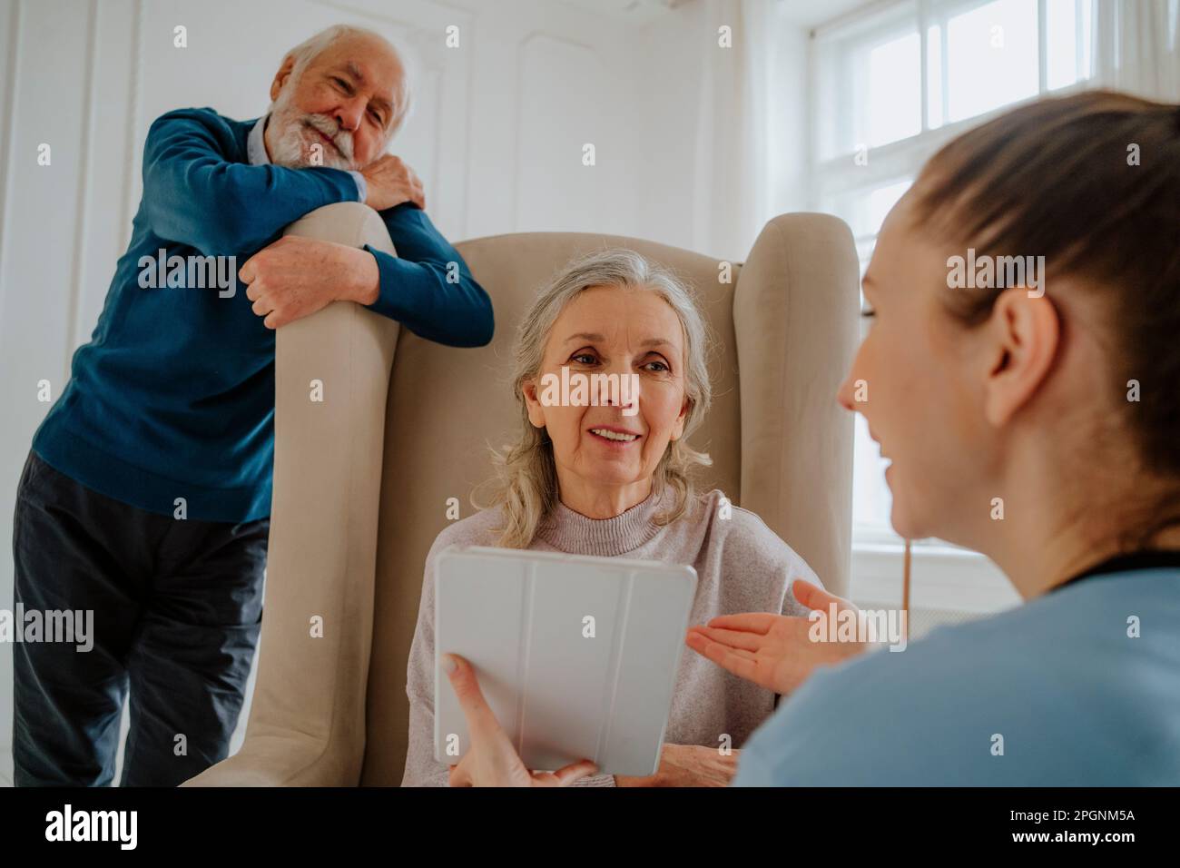 Volunteer showing tablet PC to senior patients at home Stock Photo - Alamy