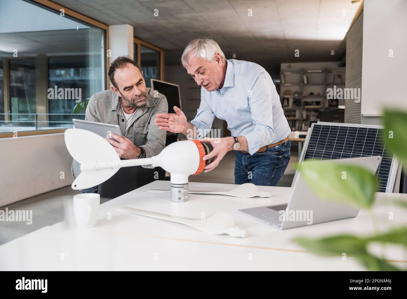 Engineer discussing together over wind turbine rotor at office Stock ...