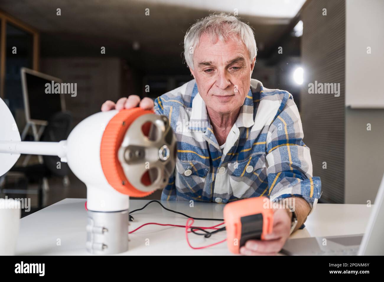 Engineer checking current of wind turbine rotor using multimeter at ...