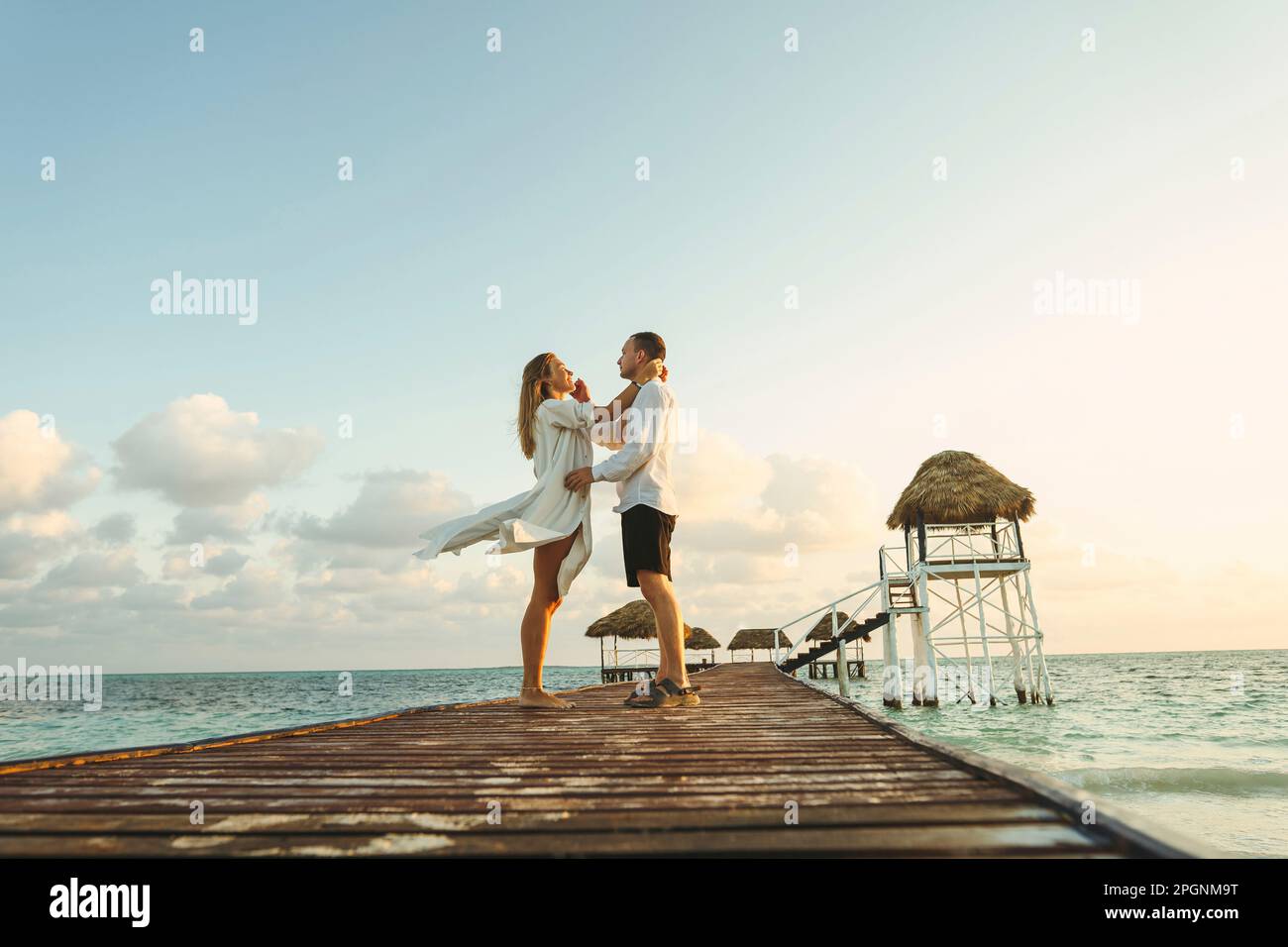 Romantic young couple standing on pier amidst sea Stock Photo - Alamy