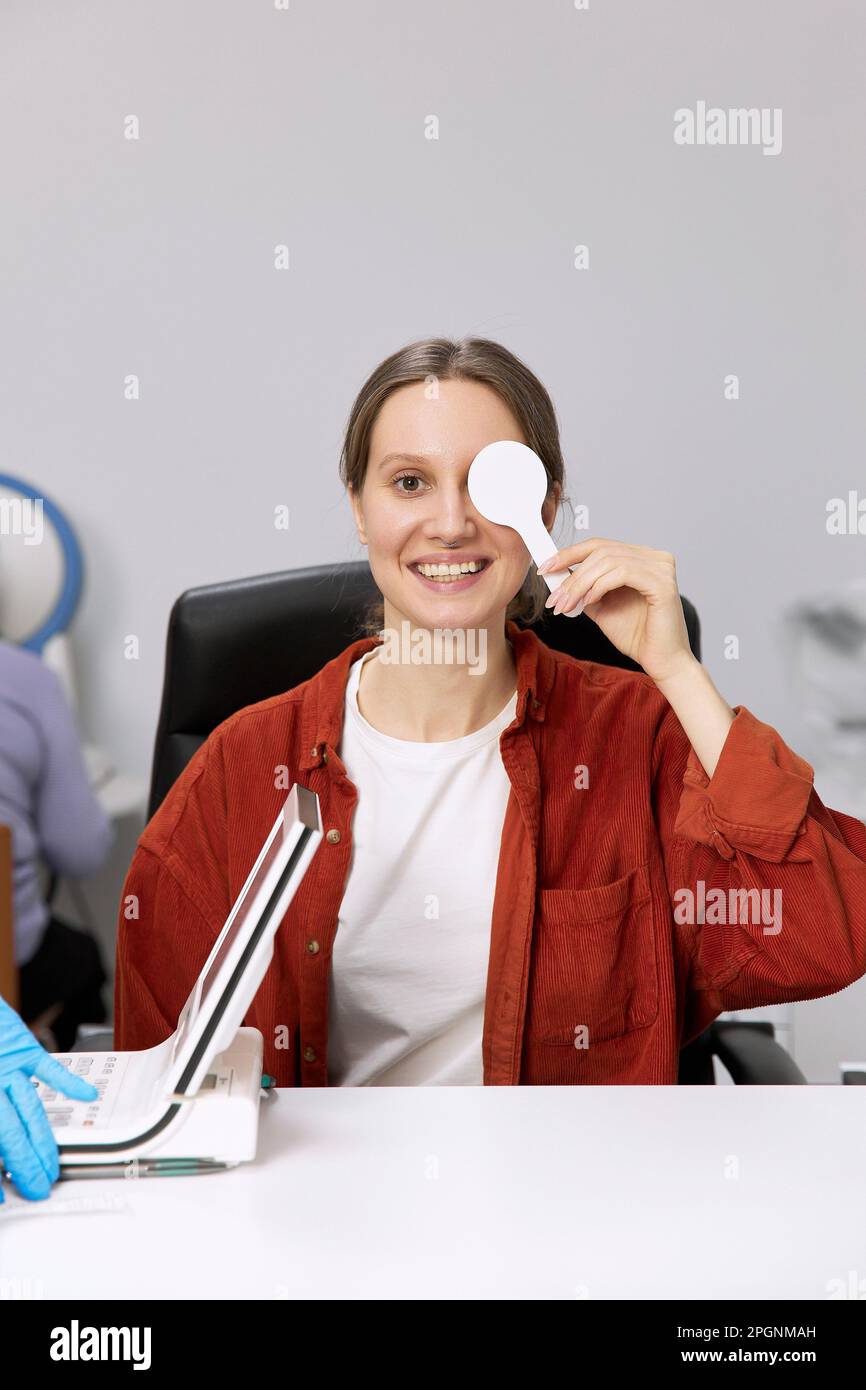 Smiling patient doing vision exam test at clinic Stock Photo - Alamy