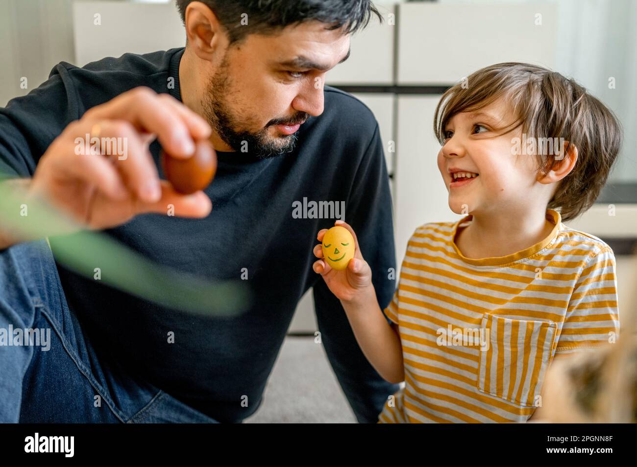 Father and son holding decorated eggs for Easter at home Stock Photo ...