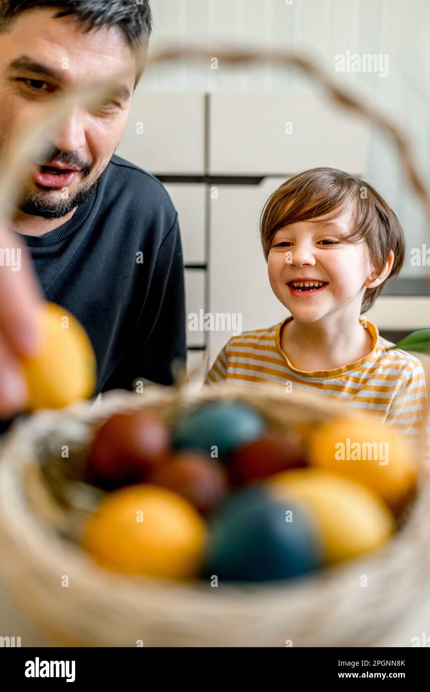 Father putting eggs in basket for Easter at home Stock Photo - Alamy
