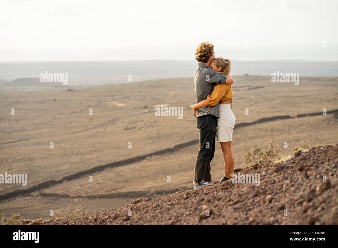 Romantic young couple embracing each other standing on mountain Stock ...