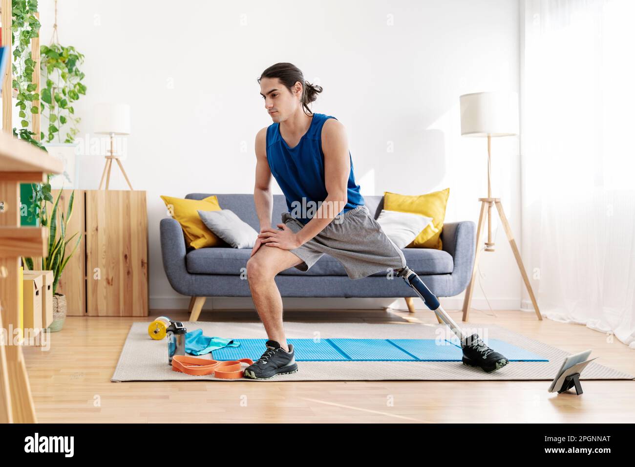 Young man with disability stretching legs at home Stock Photo - Alamy