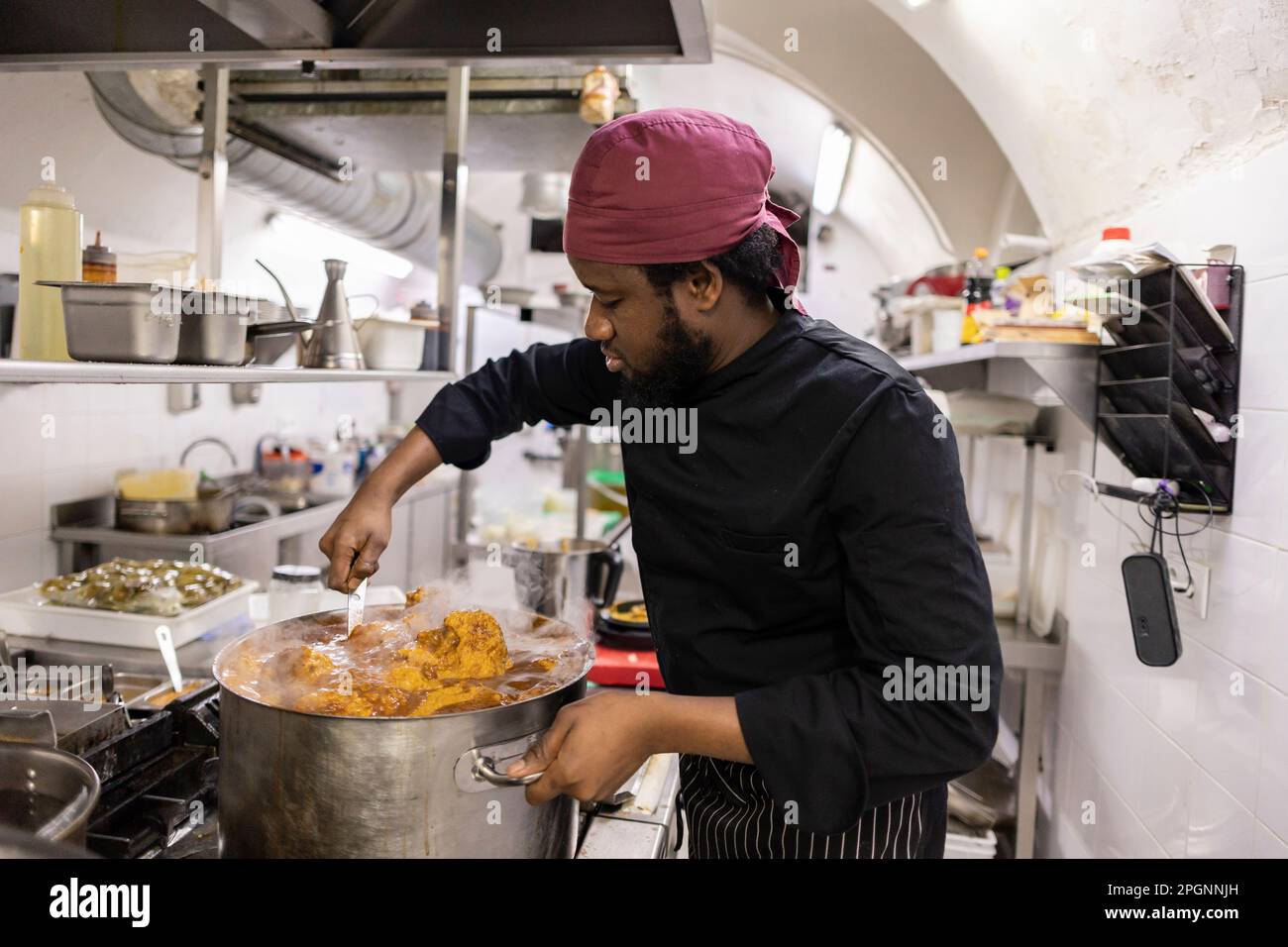 Chef stirring food in kitchen at restaurant Stock Photo - Alamy