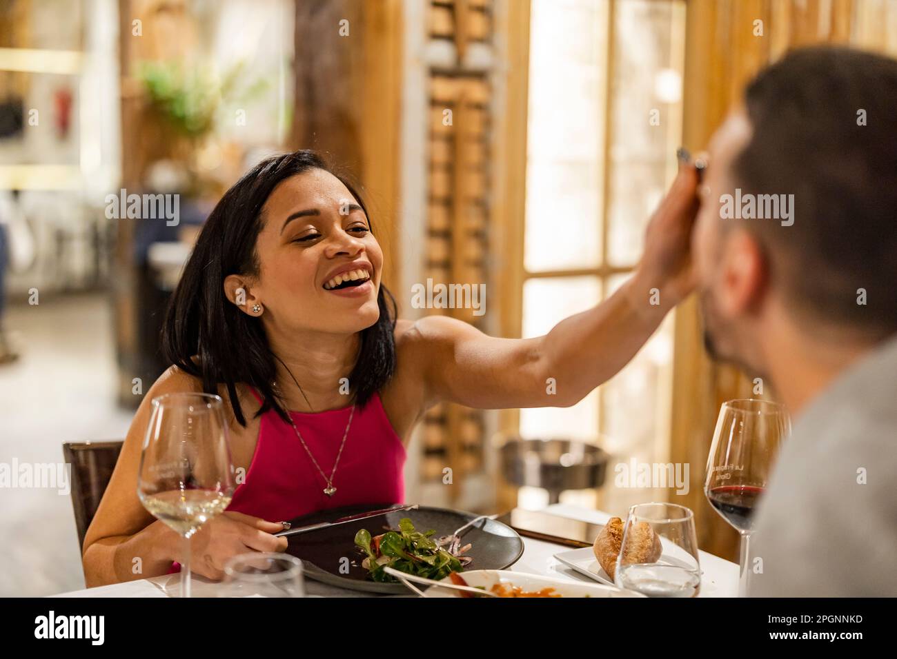 Woman feeding food to boyfriend at restaurant Stock Photo - Alamy
