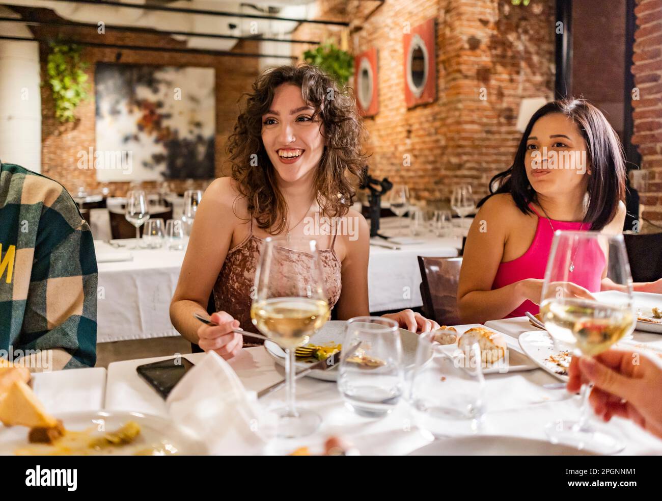 Happy women enjoying dinner with friends at restaurant Stock Photo - Alamy