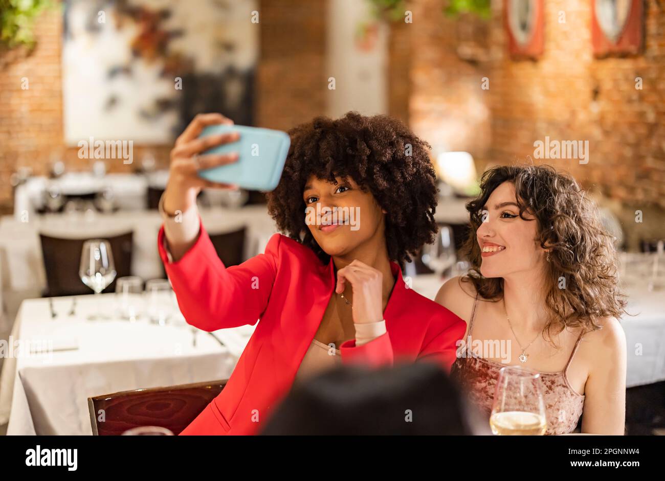 Smiling friends talking selfie at restaurant Stock Photo - Alamy