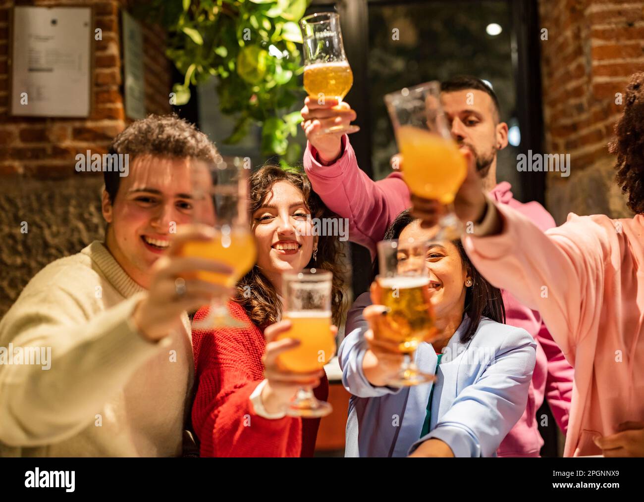 Cheerful multiracial friends raising toast at restaurant Stock Photo ...