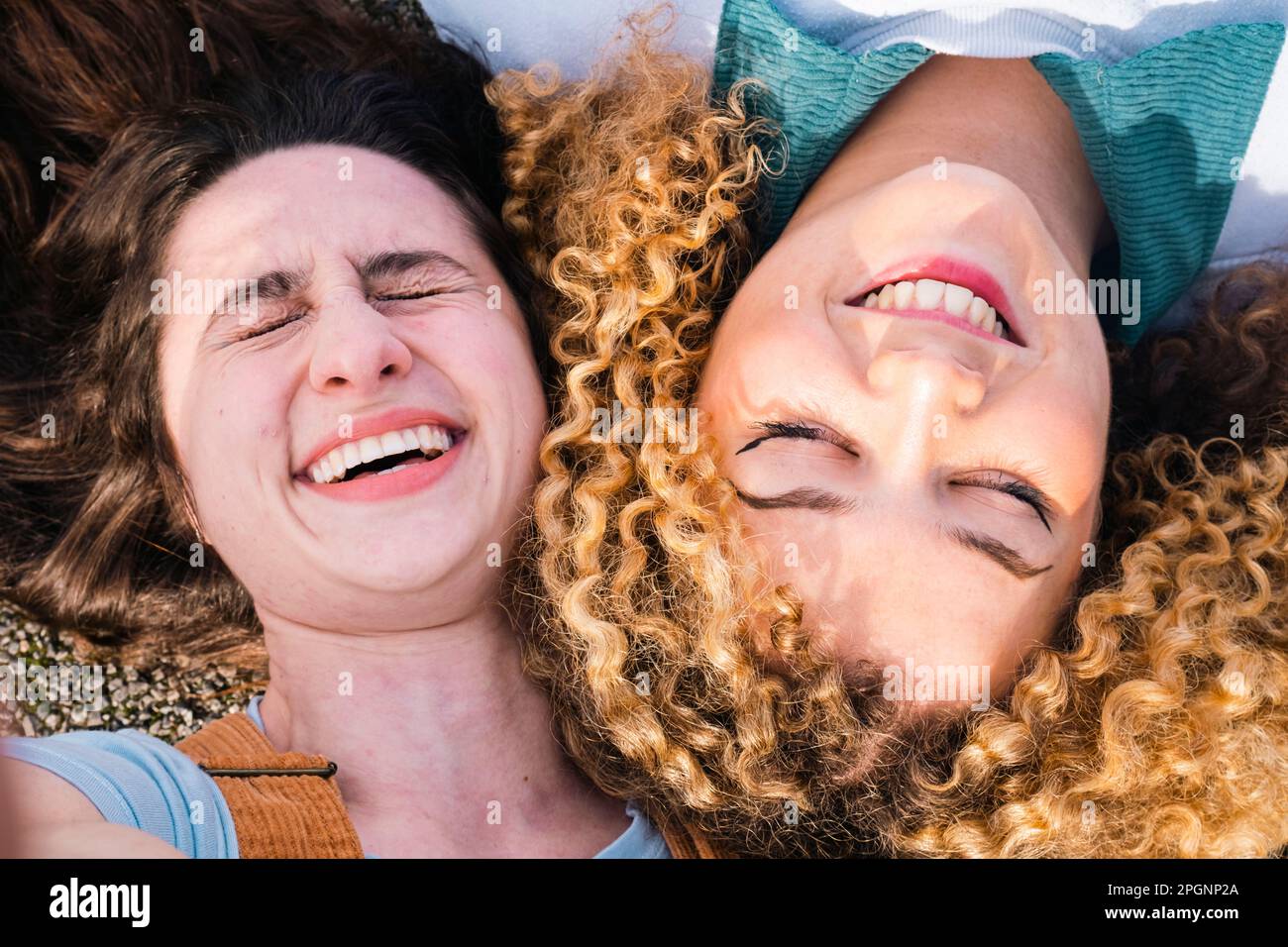 Friends lying next to each other laughing happily Stock Photo - Alamy