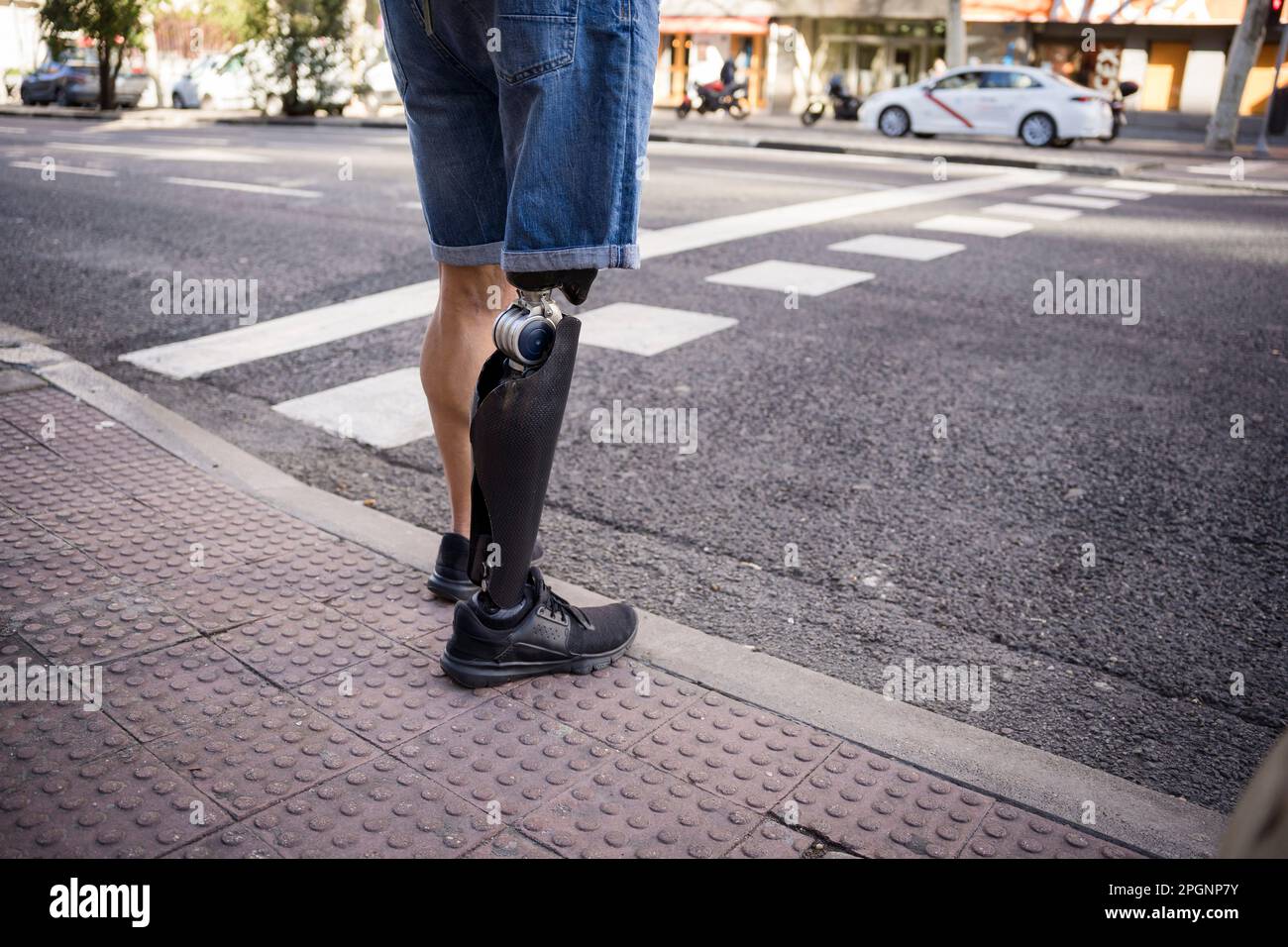 Man with prosthetic leg waiting at roadside Stock Photo - Alamy