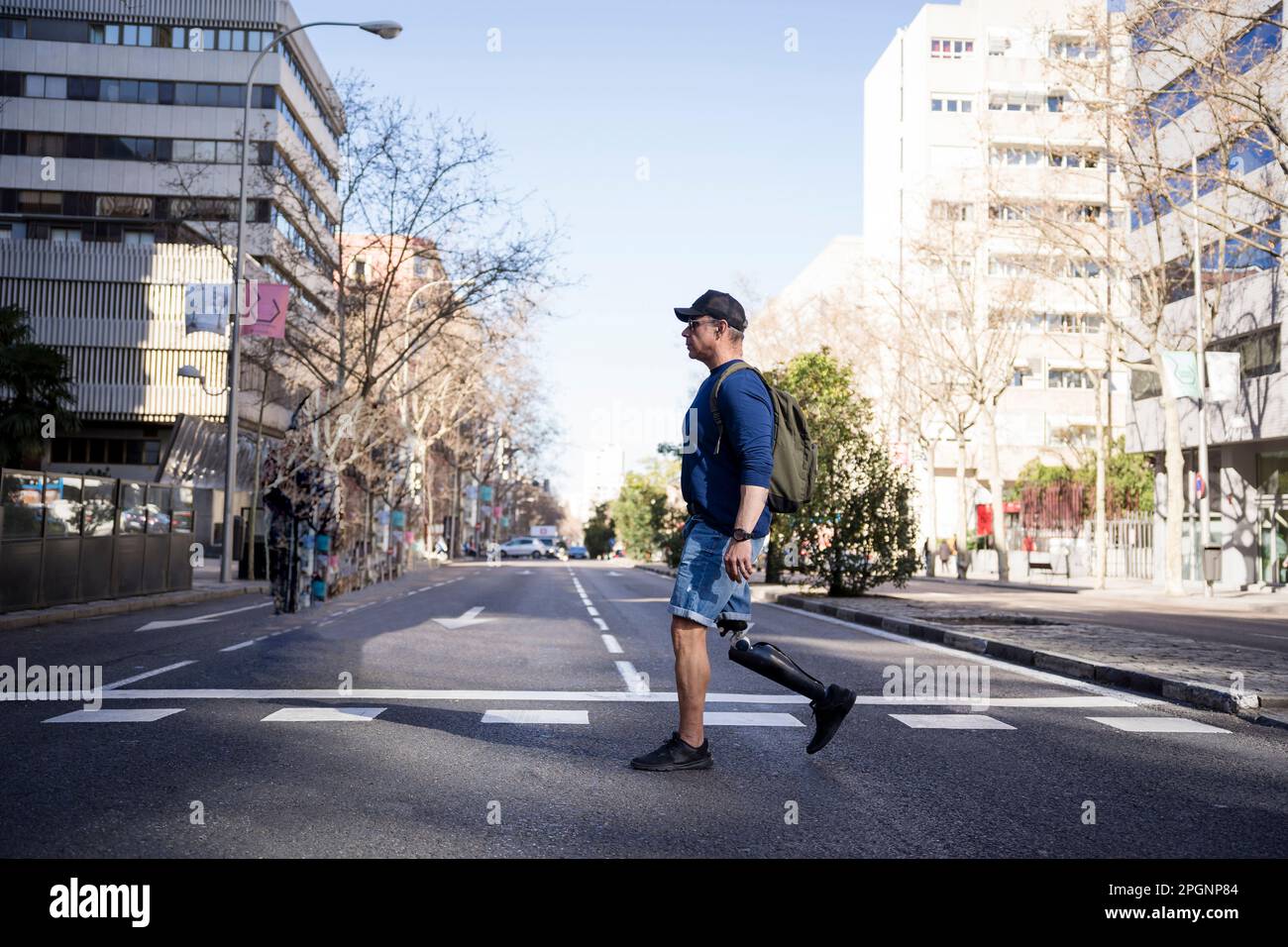 Mature man with prosthetic leg crossing road in city Stock Photo - Alamy