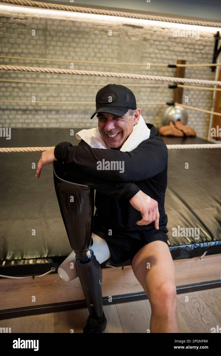 Happy man with disability sitting on boxing ring in gym Stock Photo - Alamy