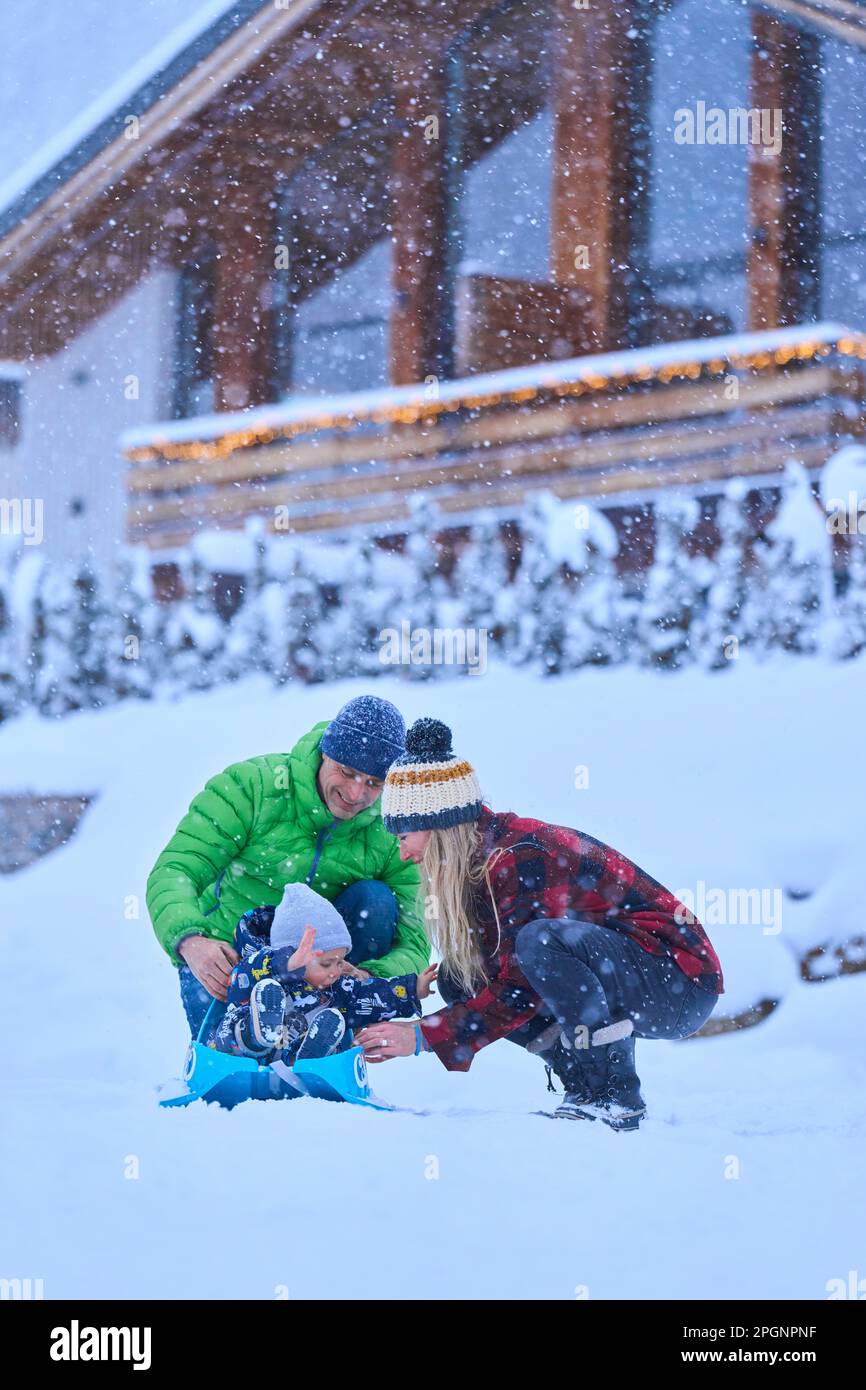 Happy family enjoying in snow Stock Photo - Alamy