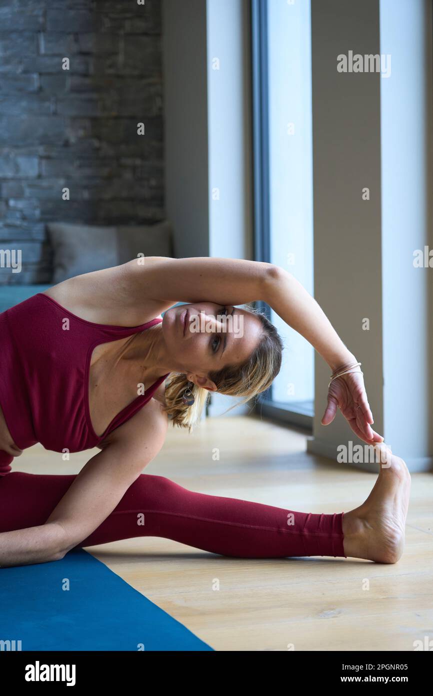 Flexible woman touching toes at home Stock Photo - Alamy