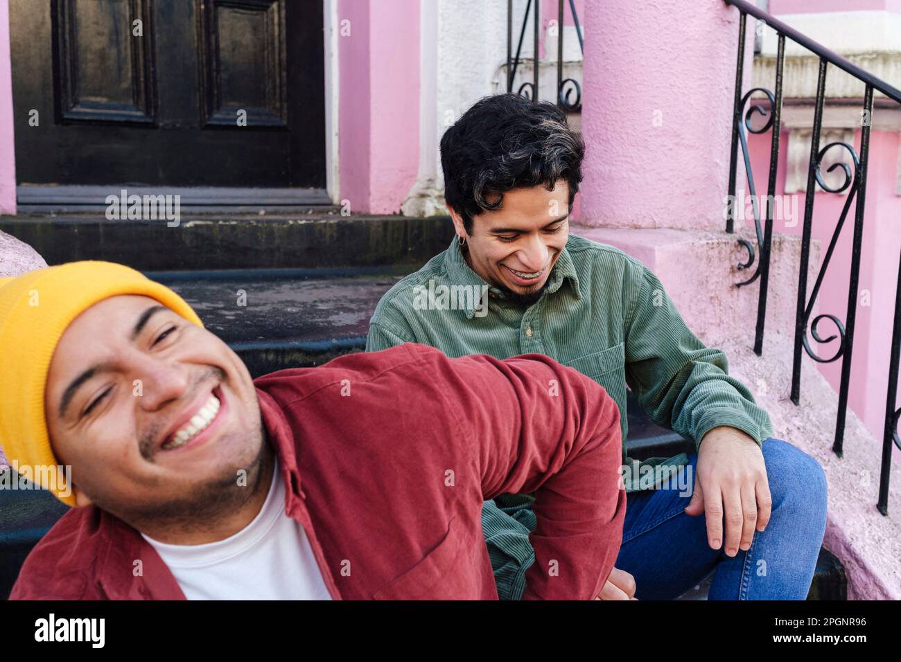 Happy brothers enjoying together sitting on steps Stock Photo - Alamy