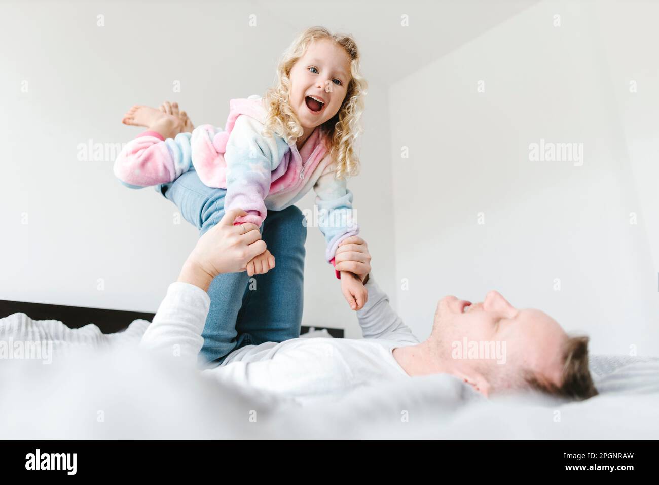 Happy daughter having fun and playing with father on bed at home Stock ...